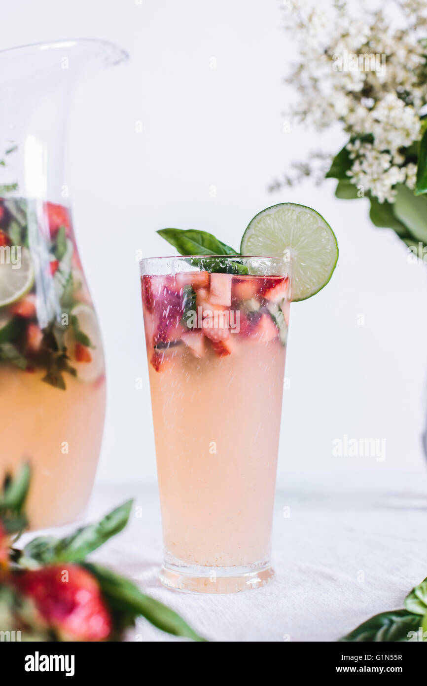A glass full of Honey Sweetened Limeade with Strawberries and Basil is ...