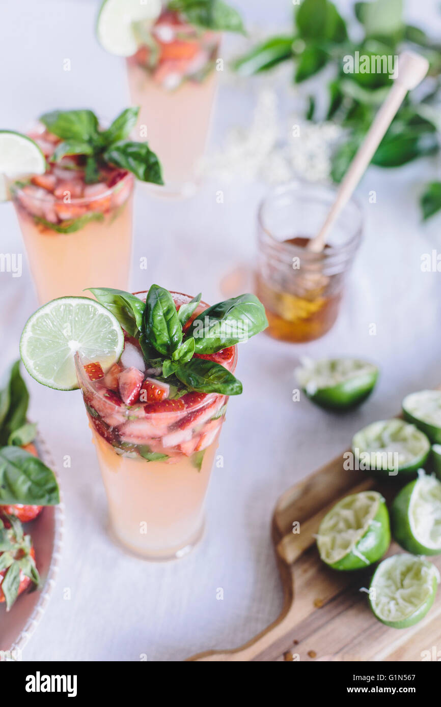 A glass of Honey Sweetened Limeade with Strawberries and Basil is ...