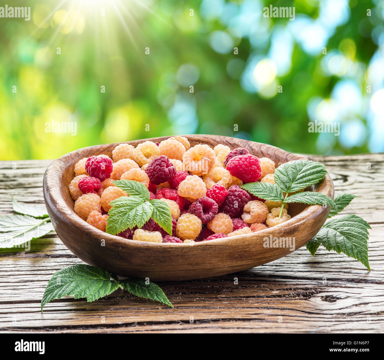 Raspberries in the wooden bowl on the table Stock Photo - Alamy