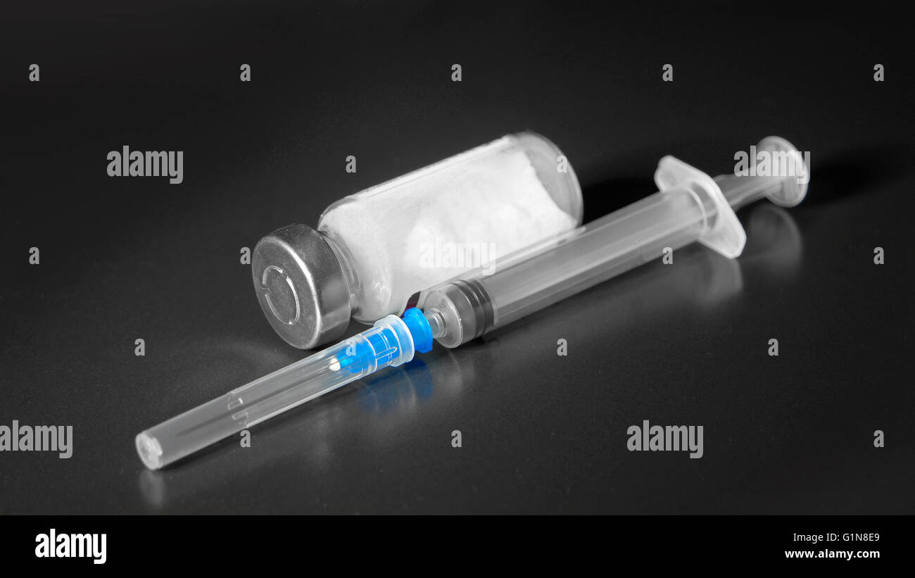 Syringe with needle and vial on black background, ready for injection ...