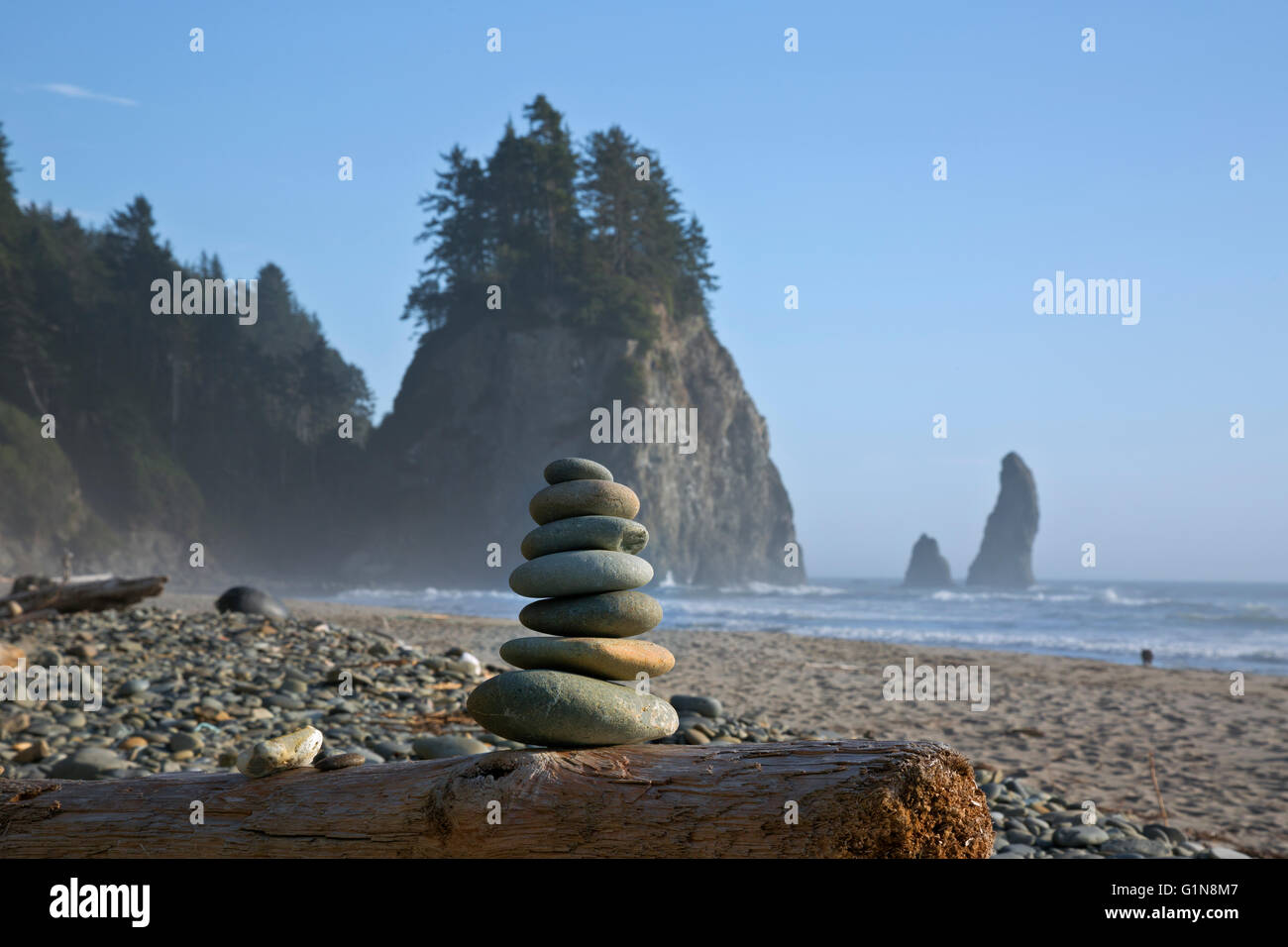 WASHINGTON - Rocks stacked on a drift log at Mosquito Creek on a ...