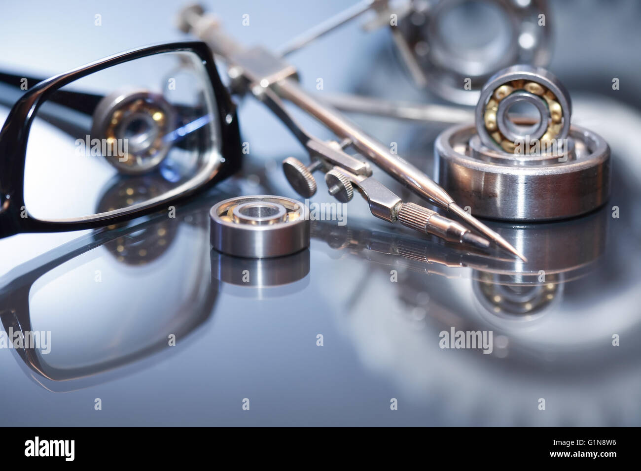 Industrial concept. Spectacles near divider and gear on glass surface ...