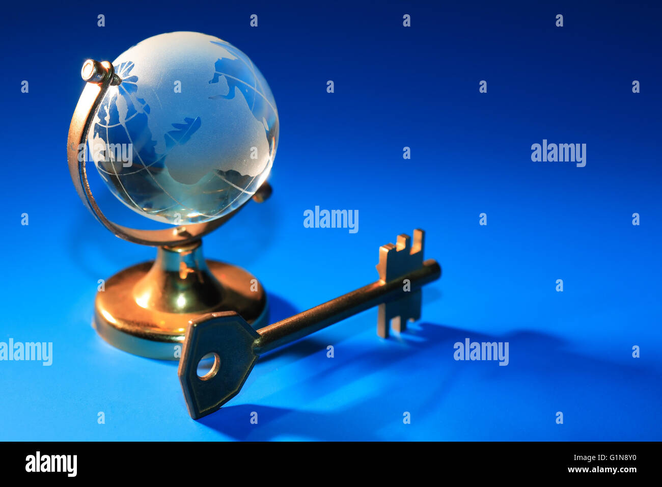Glass globe near key on blue background with free space Stock Photo - Alamy