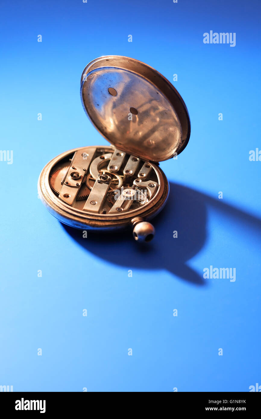 Old pocket watch back side with open mechanism on blue background Stock ...