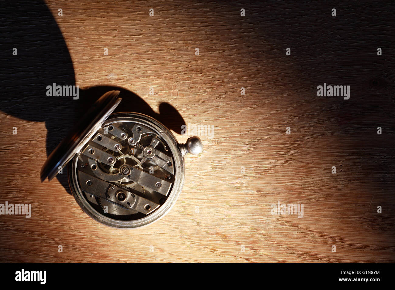 Vintage pocket watch back side with open mechanism on wooden background ...