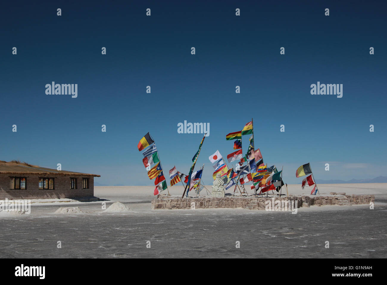 World flags against a blue sky on Uyuni salt flat in Bolivia Stock ...