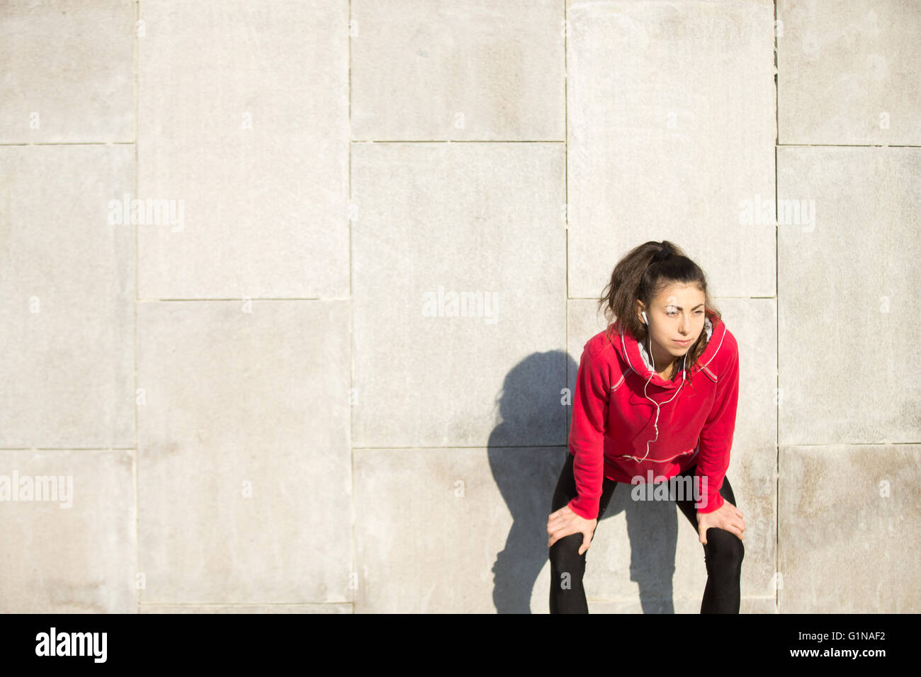 Portrait of young beautiful female leaning on gray background while ...