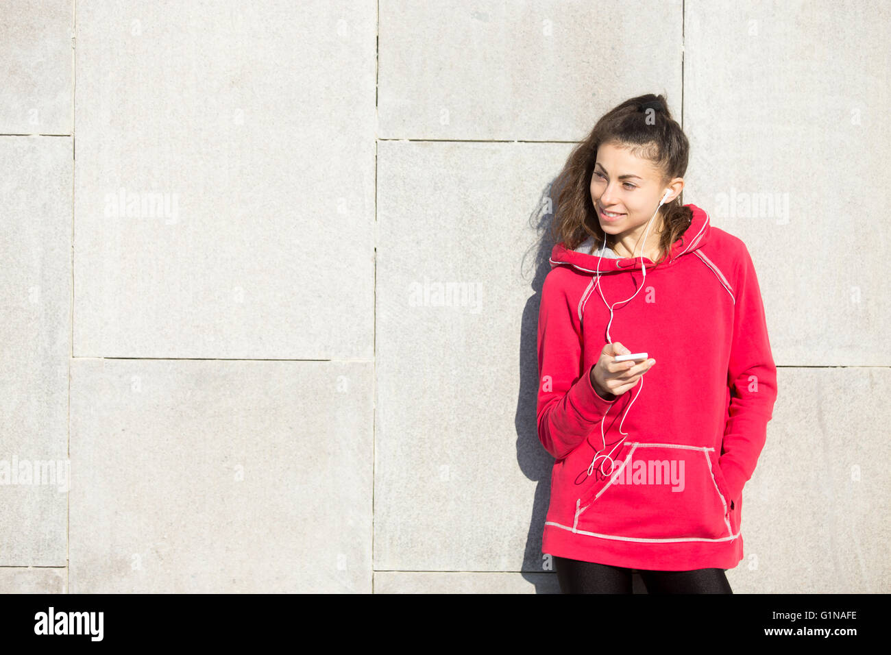 Portrait of young happy beautiful female leaning on gray background ...