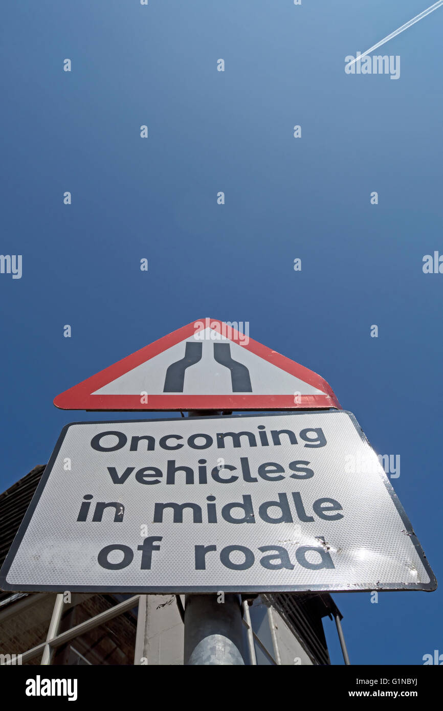 british road sign for narrowing road and stating oncoming vehicles in ...