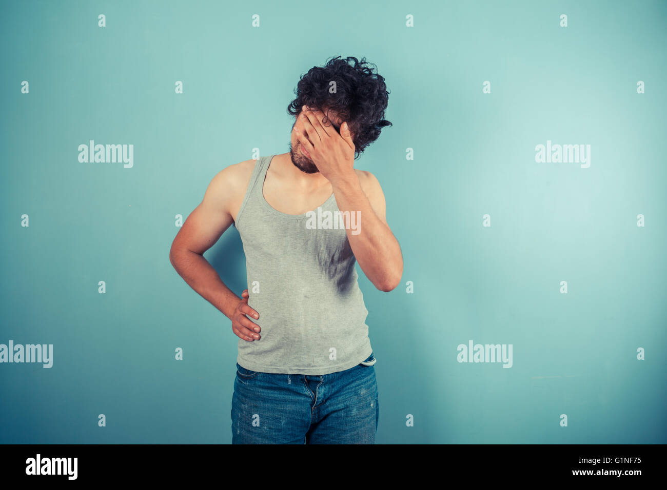 A young man is holding his face in his palms Stock Photo - Alamy