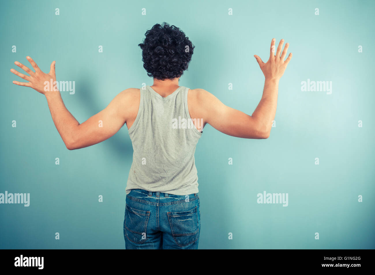 Rear view of a young man with his arms raised Stock Photo - Alamy