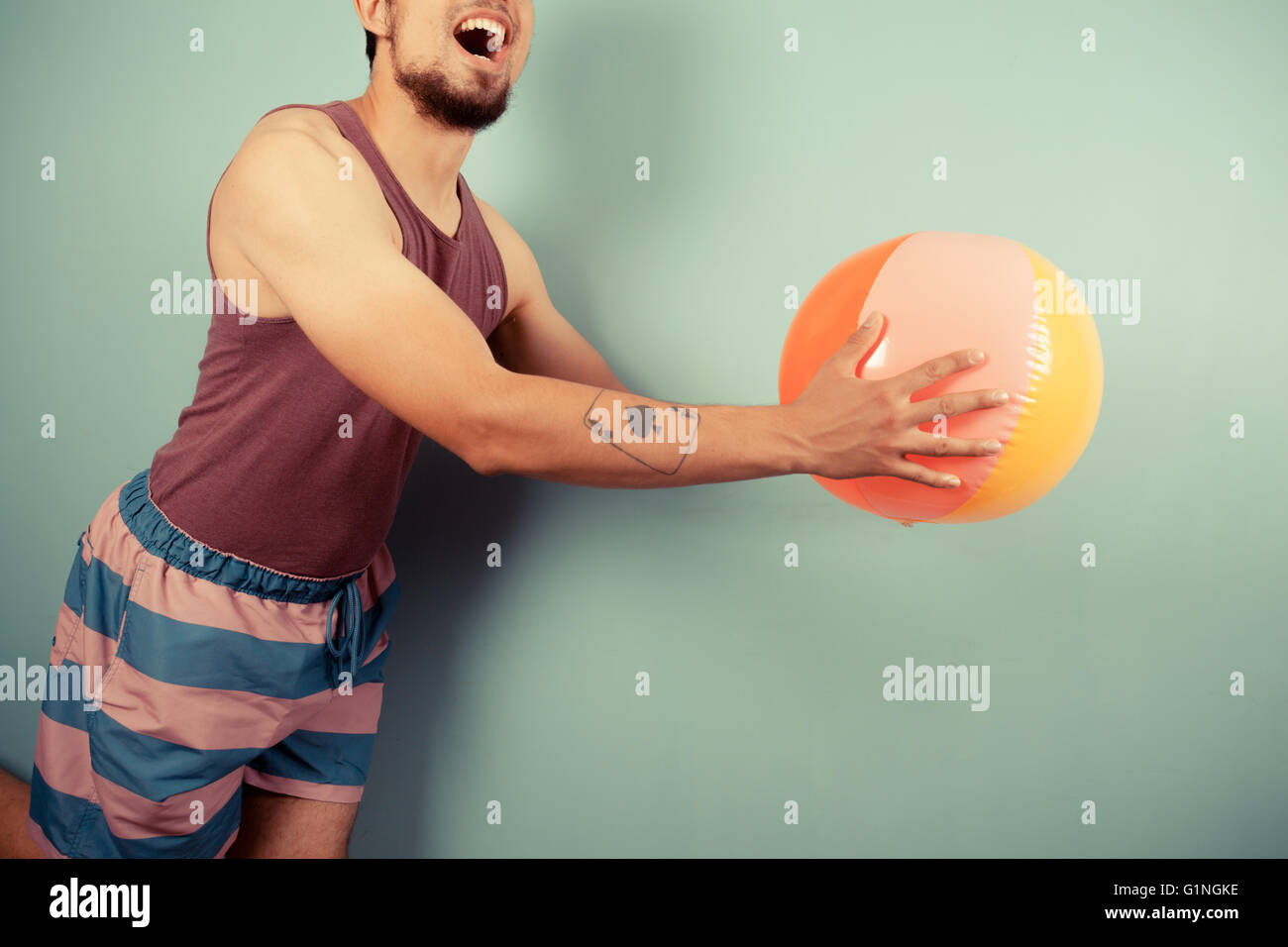 A young man is catching a beach ball Stock Photo - Alamy