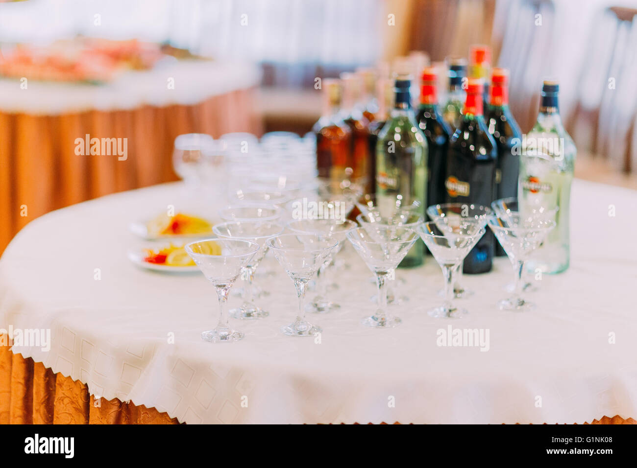 Close-up view of restaurant table setting with glasses and wine bottles ...