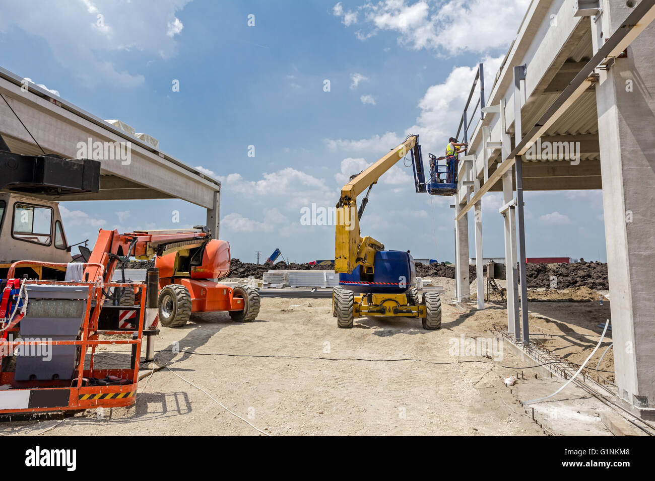 High elevated cherry picker with team of workers on construction site ...