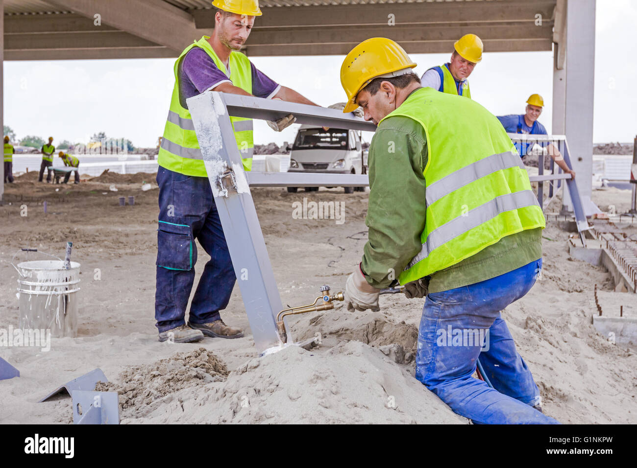 Metalworker is increasing holes diameter using metal torch. Worker is ...