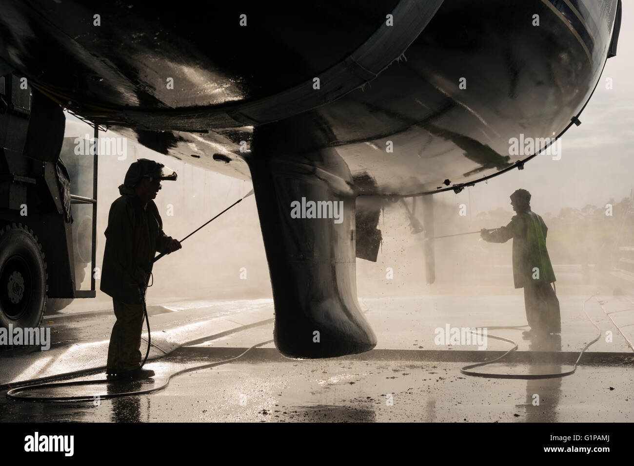 Two men jet spraying a sailing yacht that has been hauled out at Gulf ...