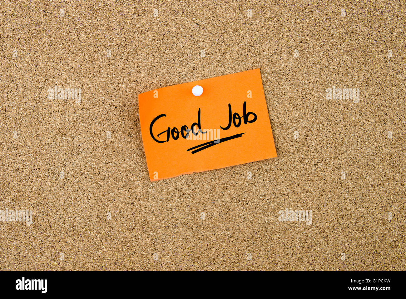 Good Job written on orange paper note pinned on cork board with white ...