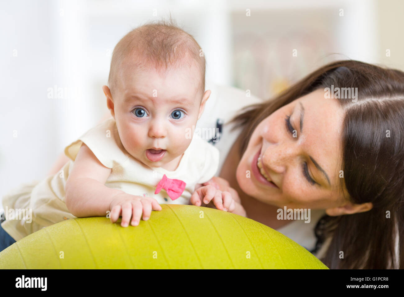 Mother with little child doing exercises with gymnastic ball. Concept of caring for the baby's ...