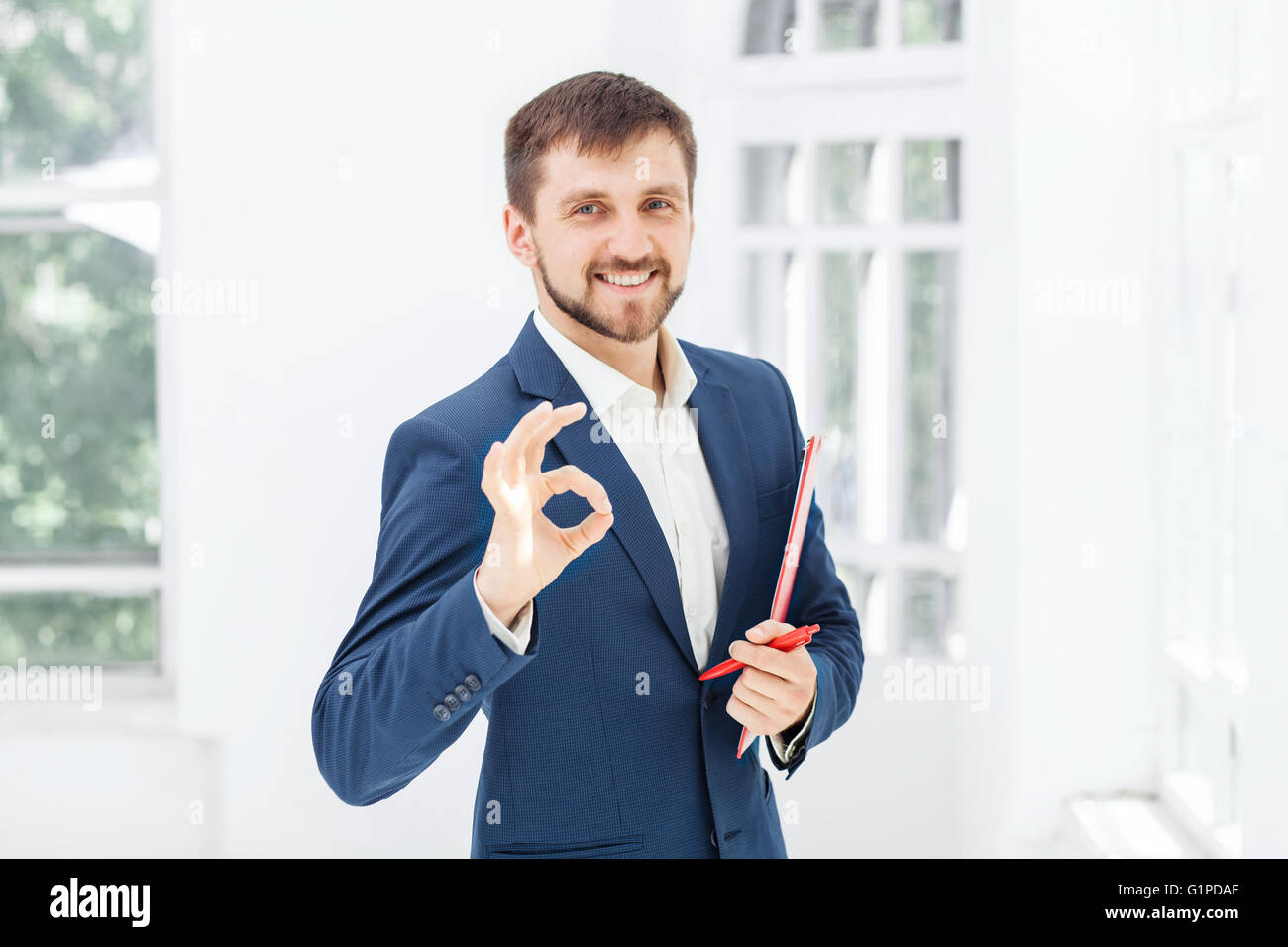 The smiling male office worker against white office Stock Photo - Alamy