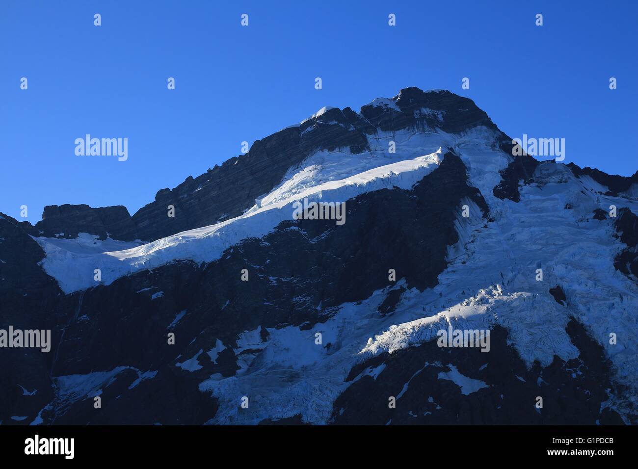 High mountain near Mount Cook. Glacier with crevasses. Evening scene ...