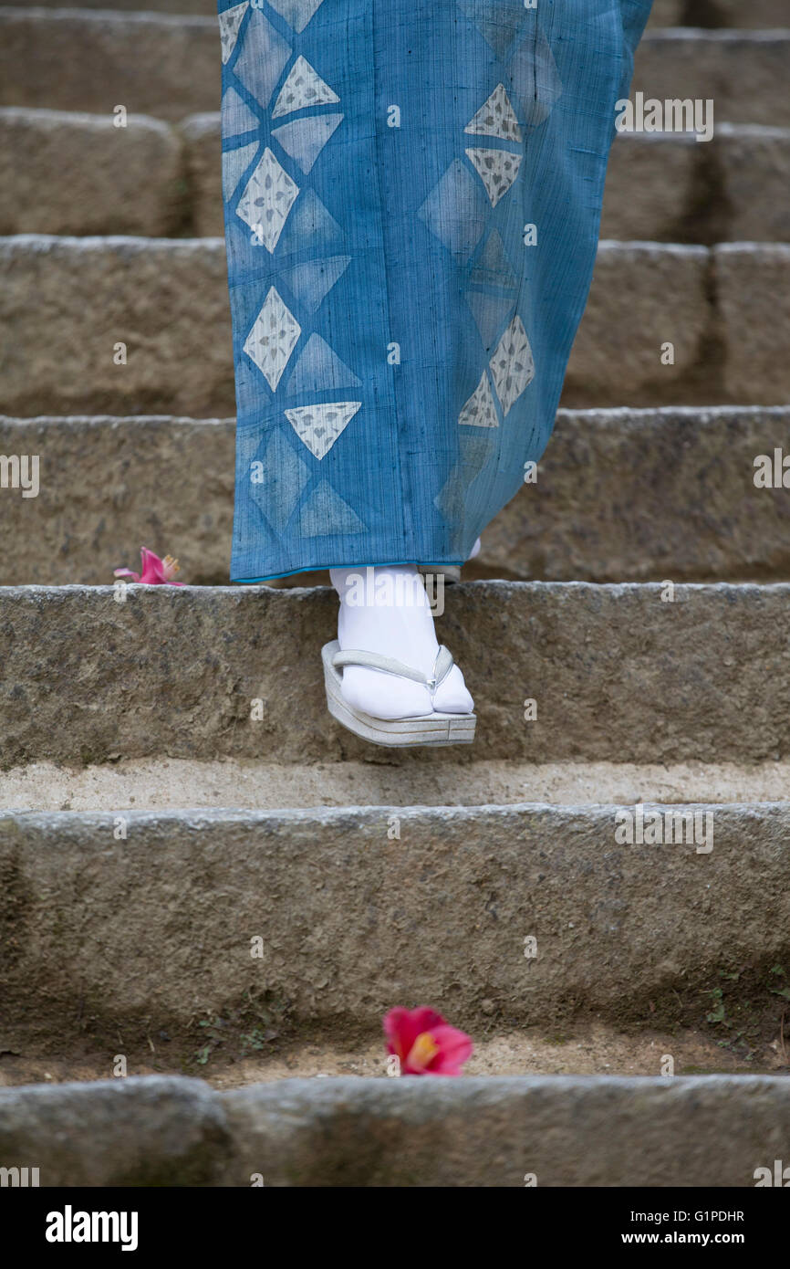 Woman's feet in kimono with Zouri (Japanese sandals) on stone stairs ...