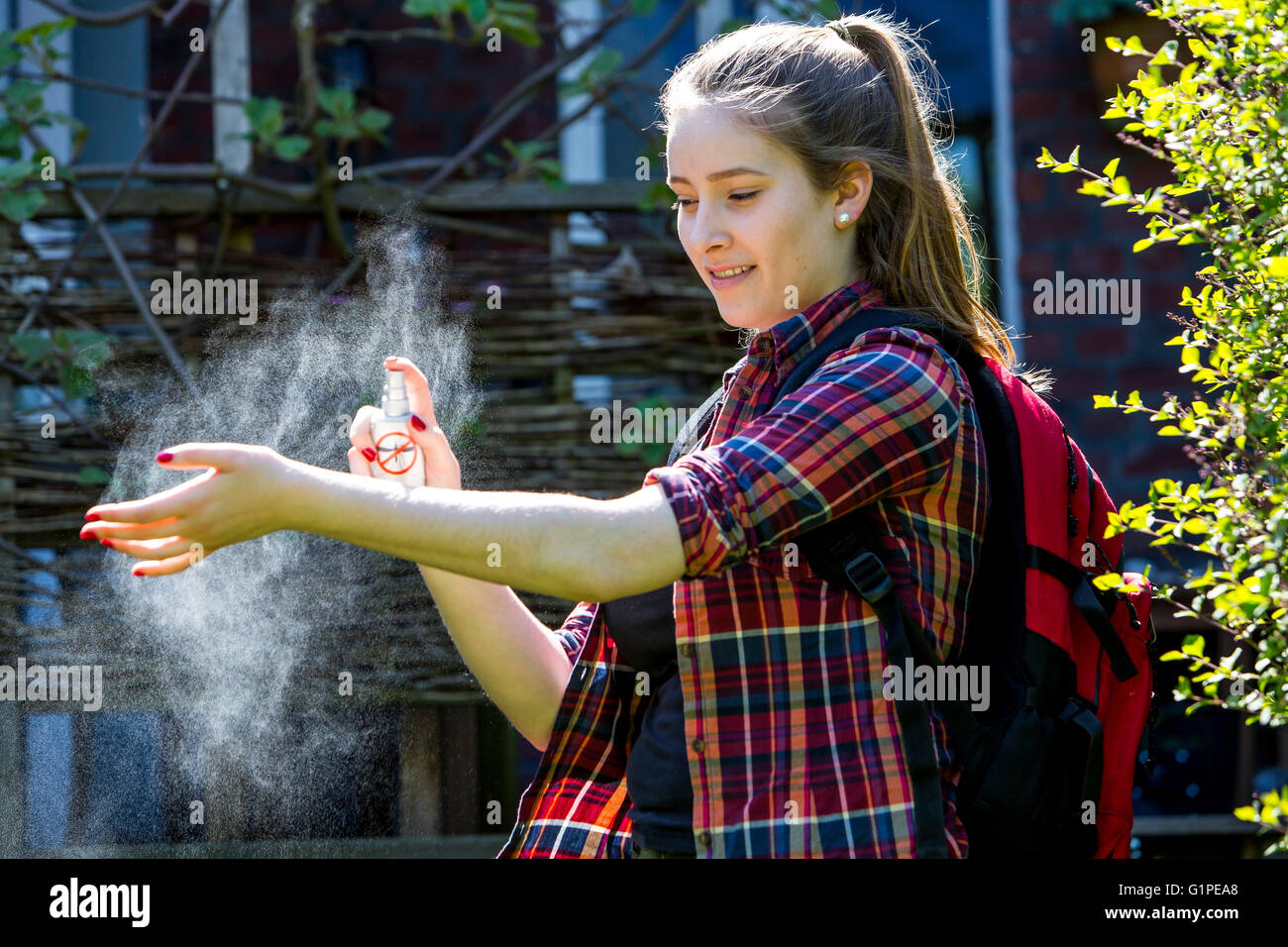 Mosquito repellent, young woman uses a spray repellent, before a hike ...