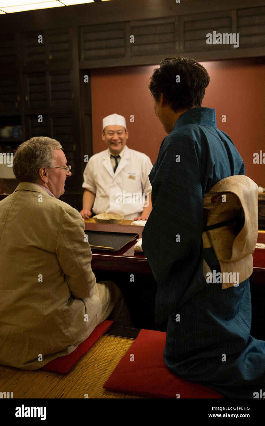 Mature Caucasian man talking with Japanese hostess and cook Stock Photo ...