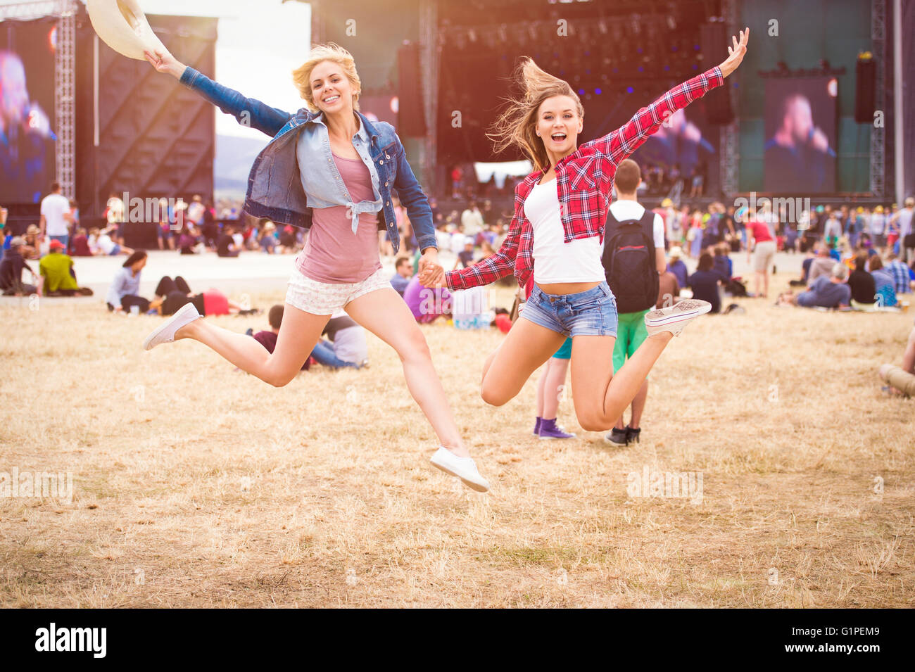 Teenage girls, music festival, jumping, in front of stage Stock Photo ...