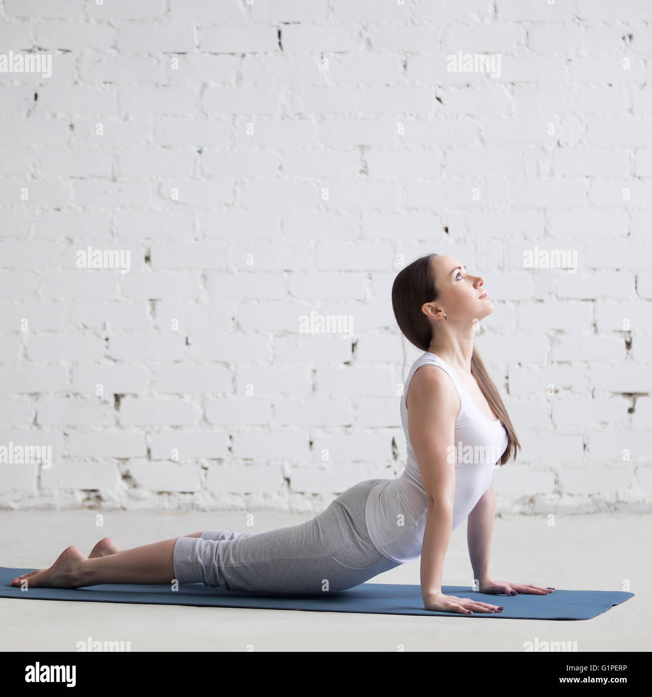 Attractive happy young woman working out indoors. Side view portrait of ...