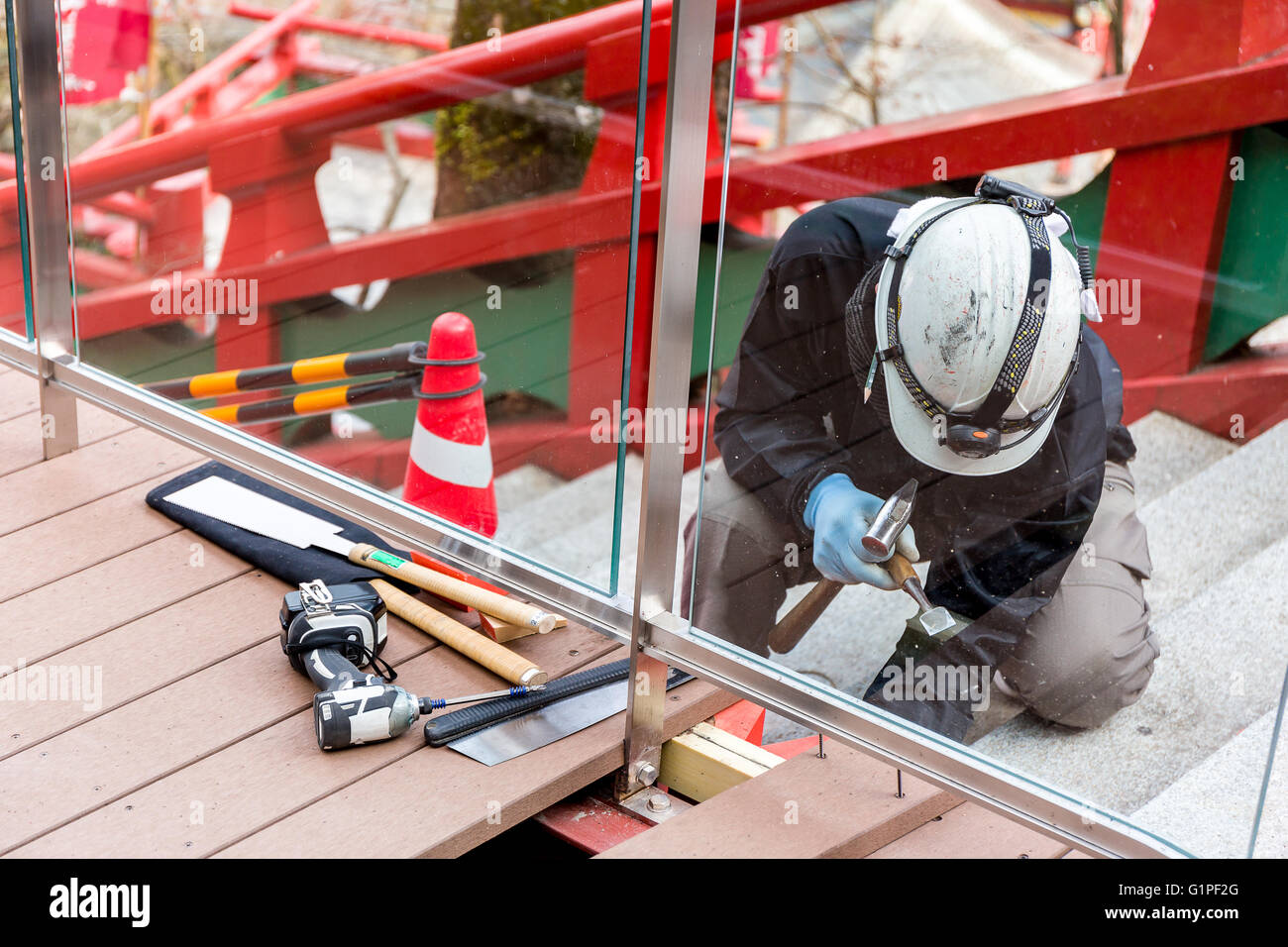 Worker fixing part of stairs with equipment Stock Photo - Alamy