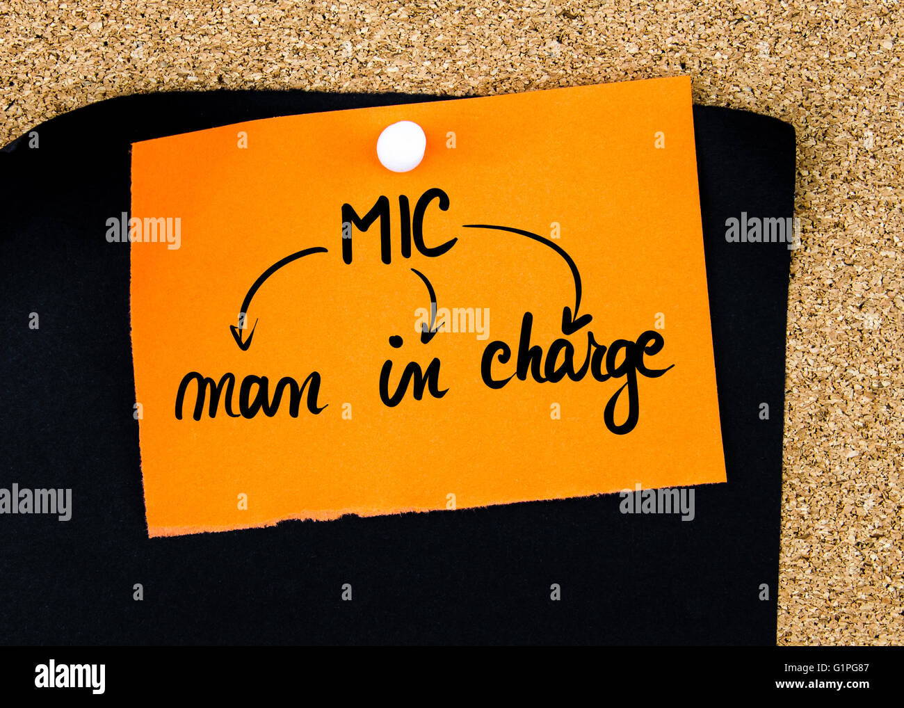 Business Acronym MIC as Man In Charge written on orange paper note ...