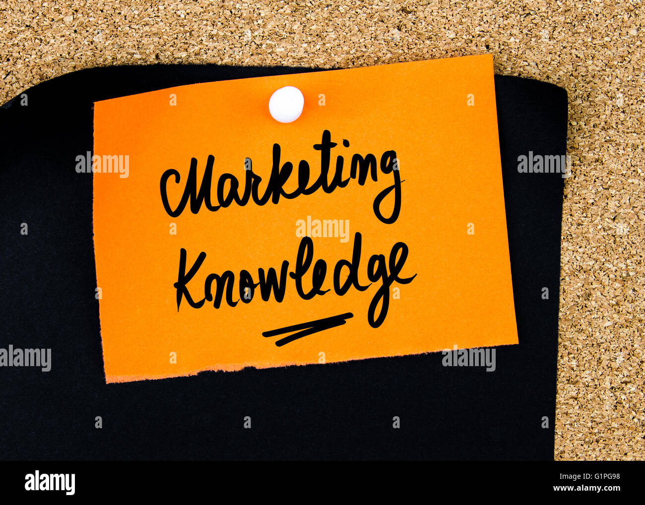 Marketing Knowledge written on orange paper note pinned on cork board ...