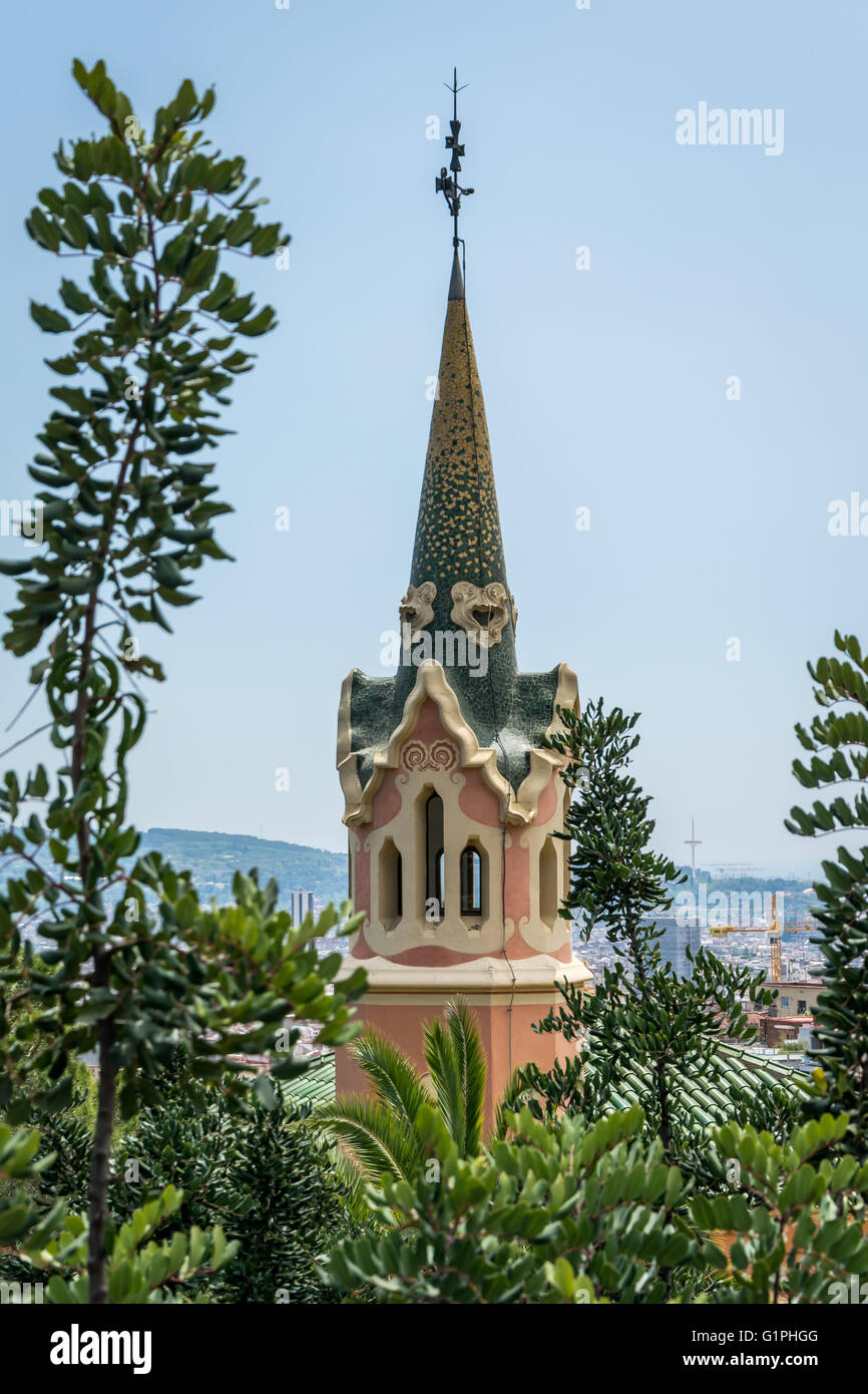 Iconic Gaudi tower, spire peaking above trees in the world famous Park ...