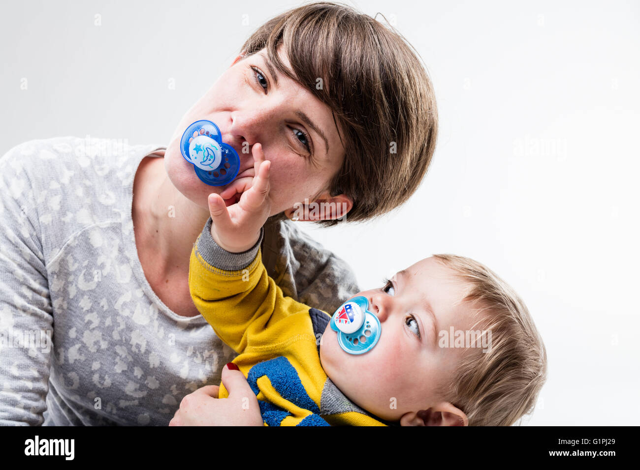 mother and son play with two pacifiers Stock Photo - Alamy