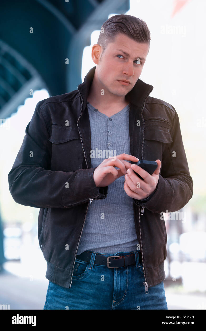 Young man typing sms in hi-res stock photography and images - Alamy