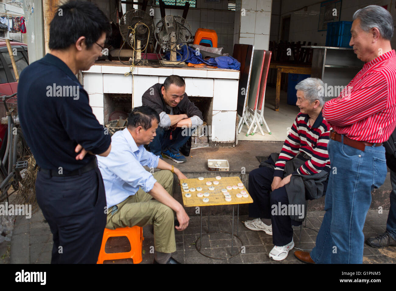 Group of Chinese men people playing majong in a street in Nanjing ...