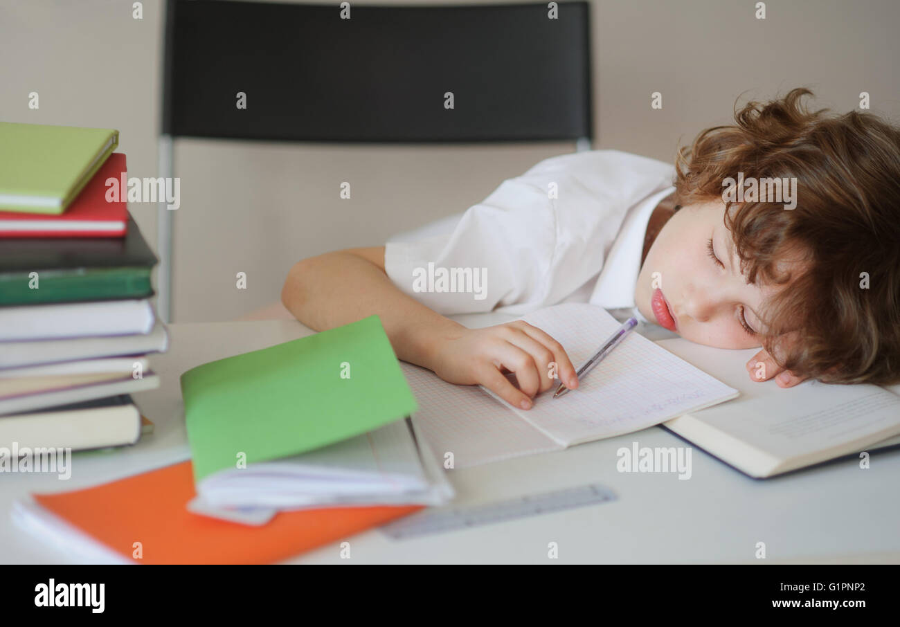 The little boy fell asleep while doing homework Stock Photo - Alamy