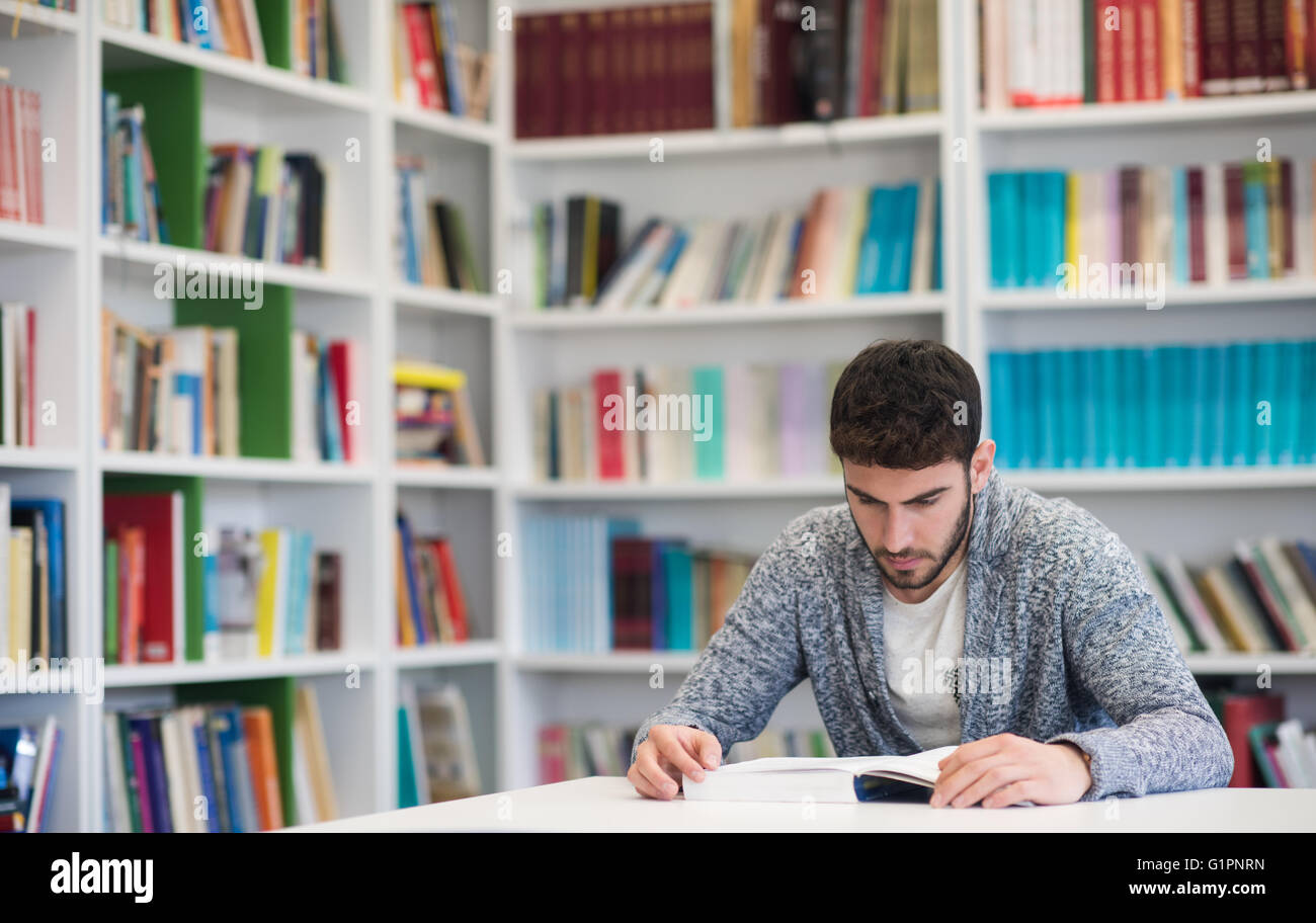 Portrait of happy student while reading book in school library. Study ...
