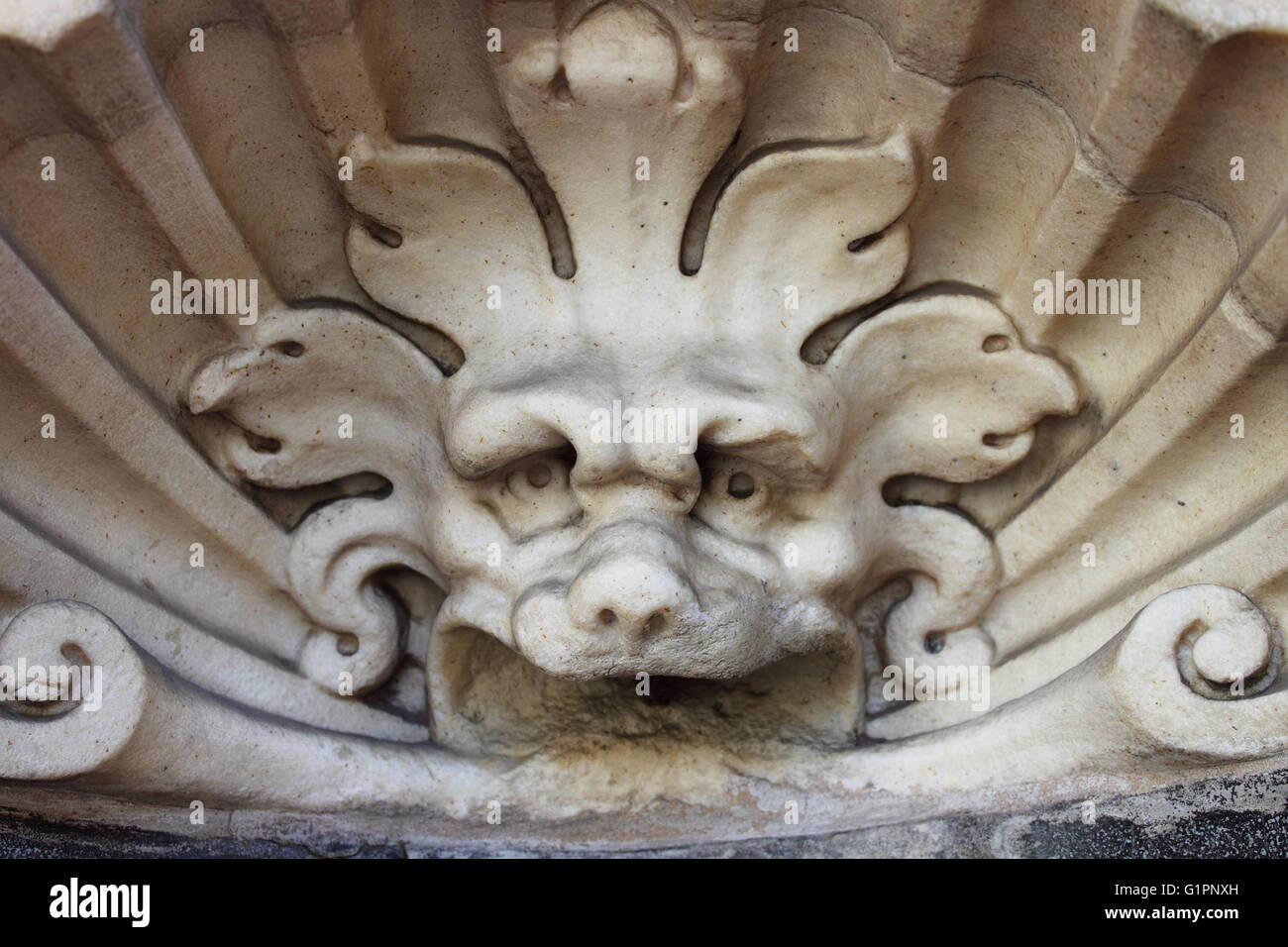 Baroque wall fountain with satyr spitting water Stock Photo - Alamy