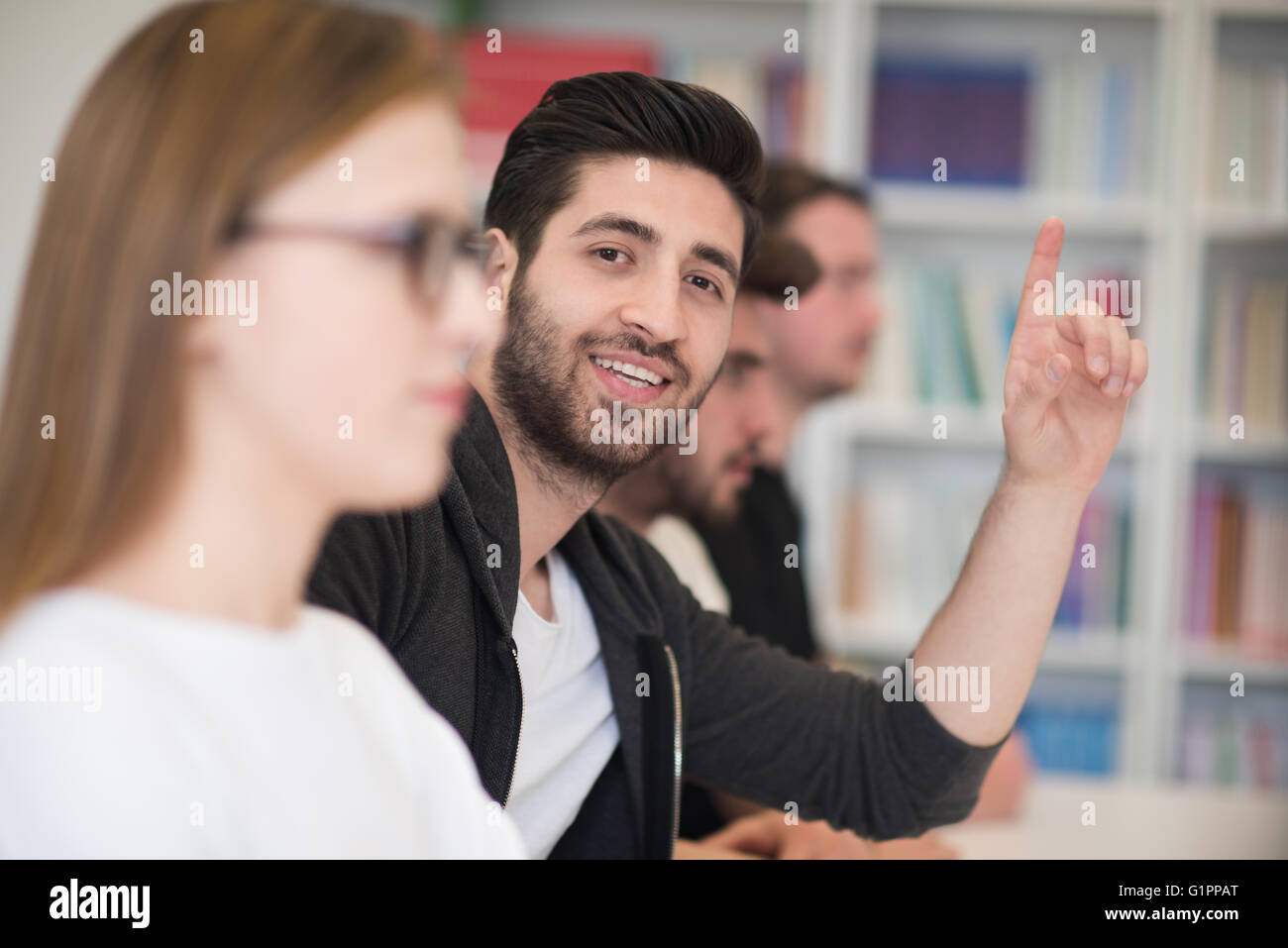 group of smart students raise hands up in school classroom on class ...
