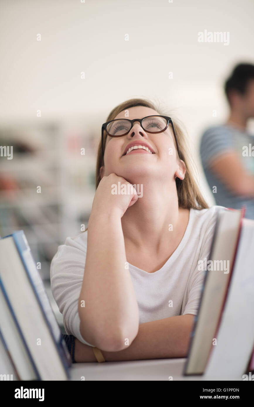 portrait of smart looking famale student girl in collage school library ...
