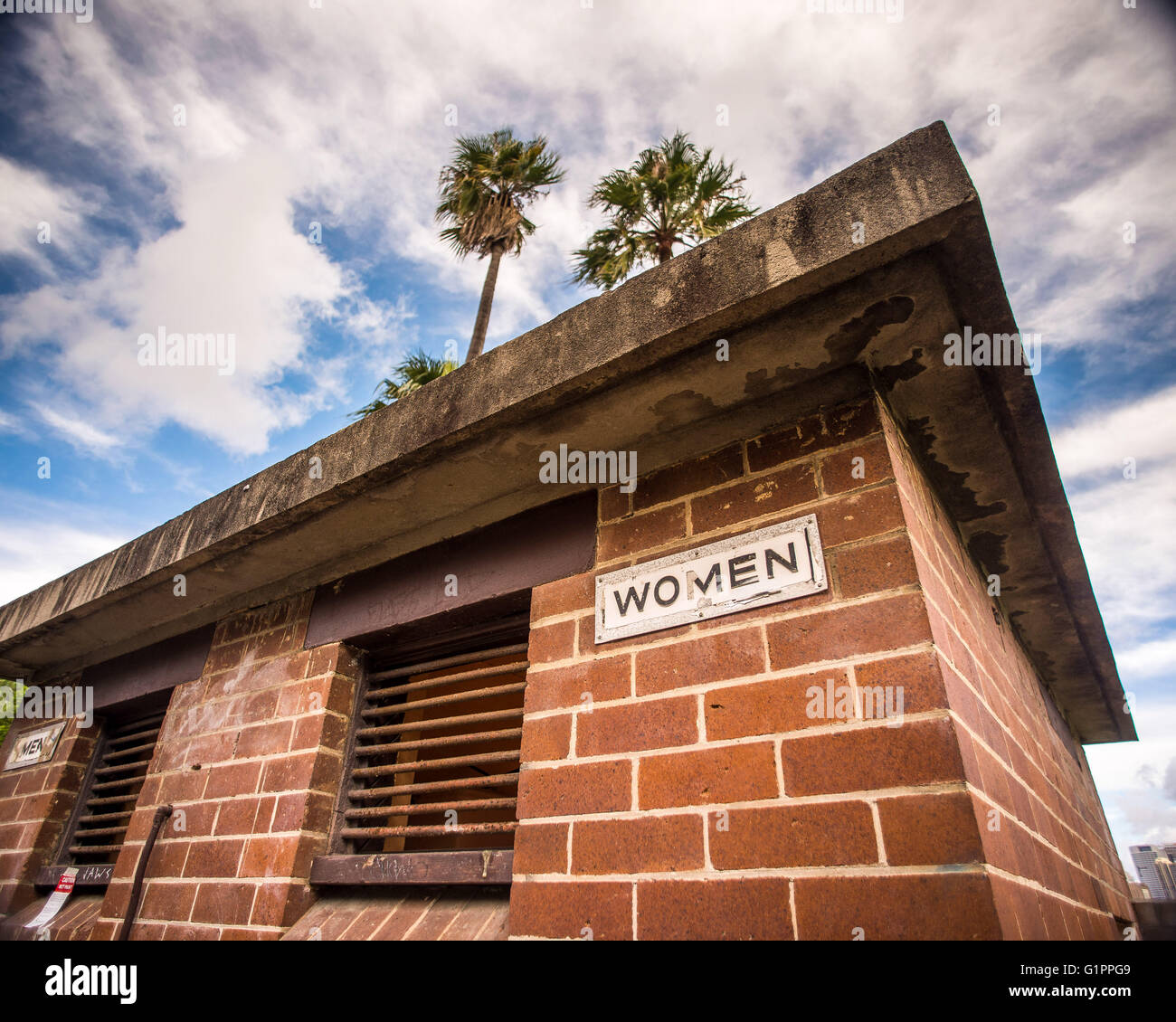 Womens female brick toilet block with sky and palmtrees in background ...