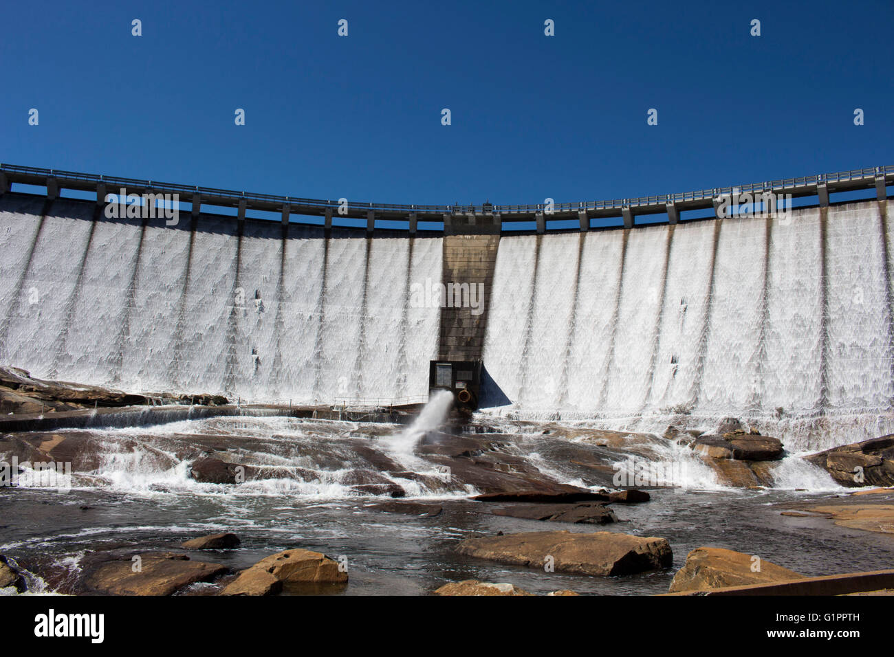 Water streaming and overflowing over the massive concrete wall and ...
