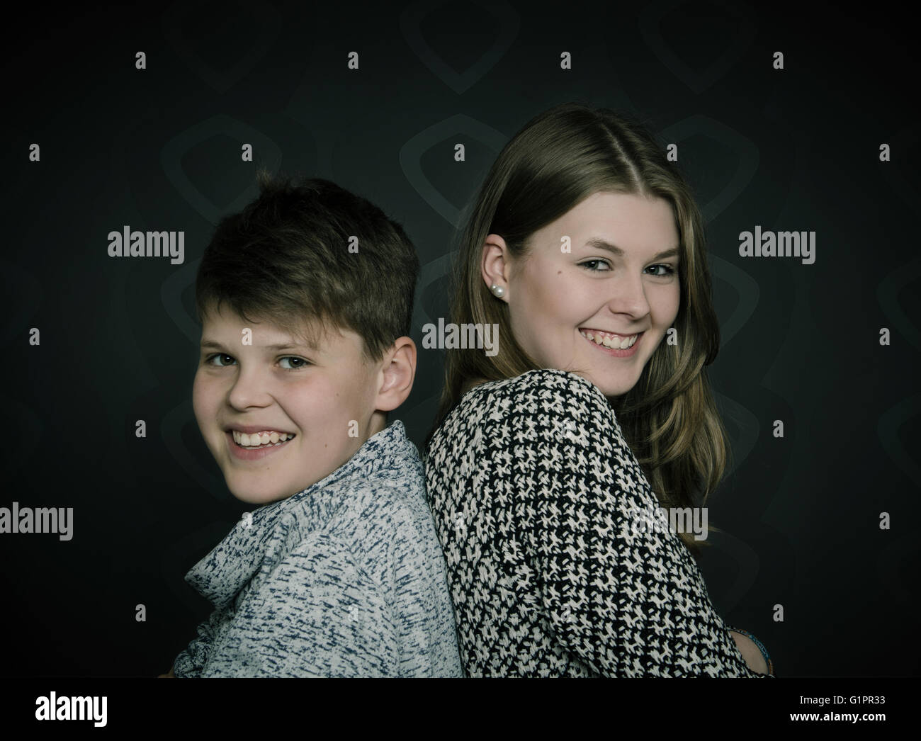Happy brother and sister on a dark background Stock Photo - Alamy