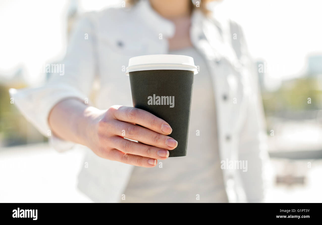 Woman's hands offering coffee cup outdoors Stock Photo - Alamy