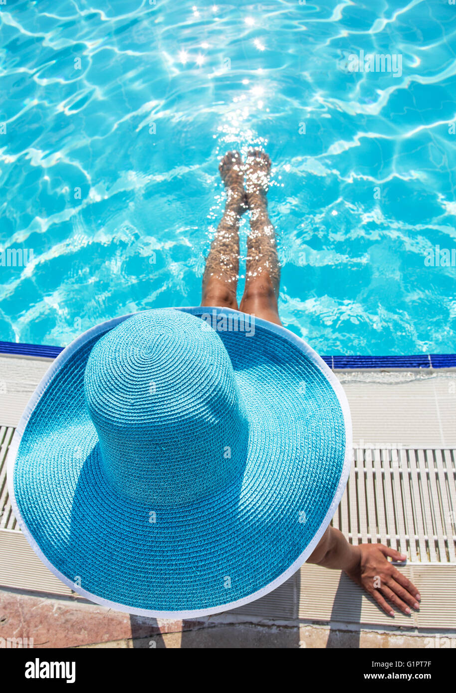 Woman sitting on the edge of swimming pool Stock Photo - Alamy