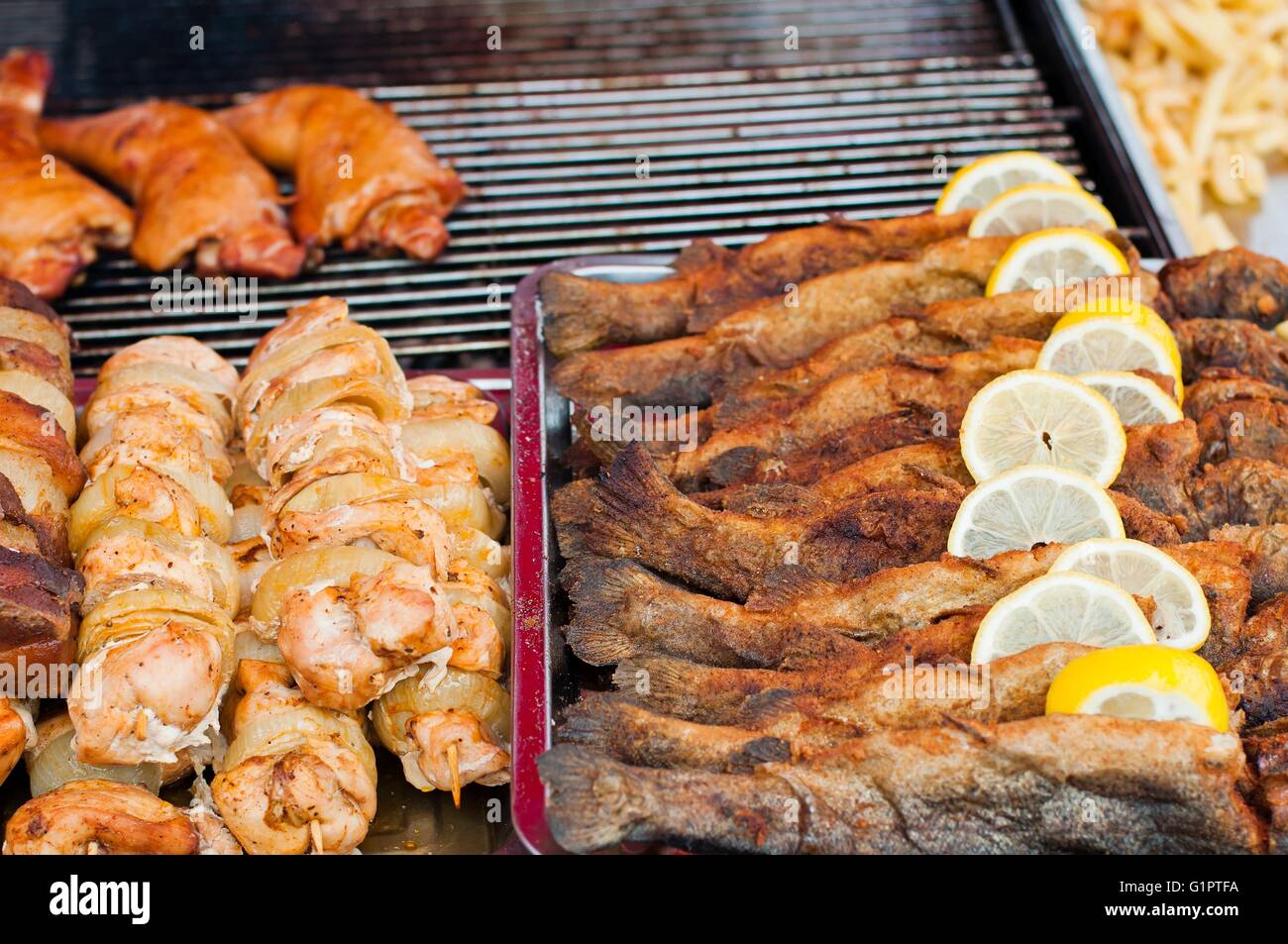 Fresh fried fish with lemon slice and grilled meat in market Stock ...