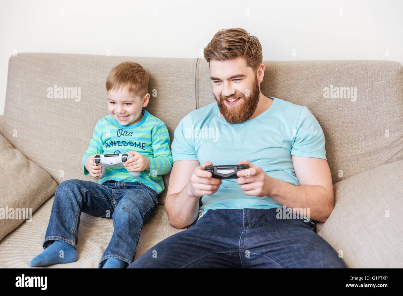 Cheerful dad and son playing computer games together at home Stock ...