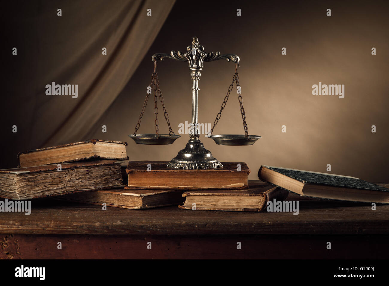 Old silver scale and hardcover books on a wooden table, justice and ...