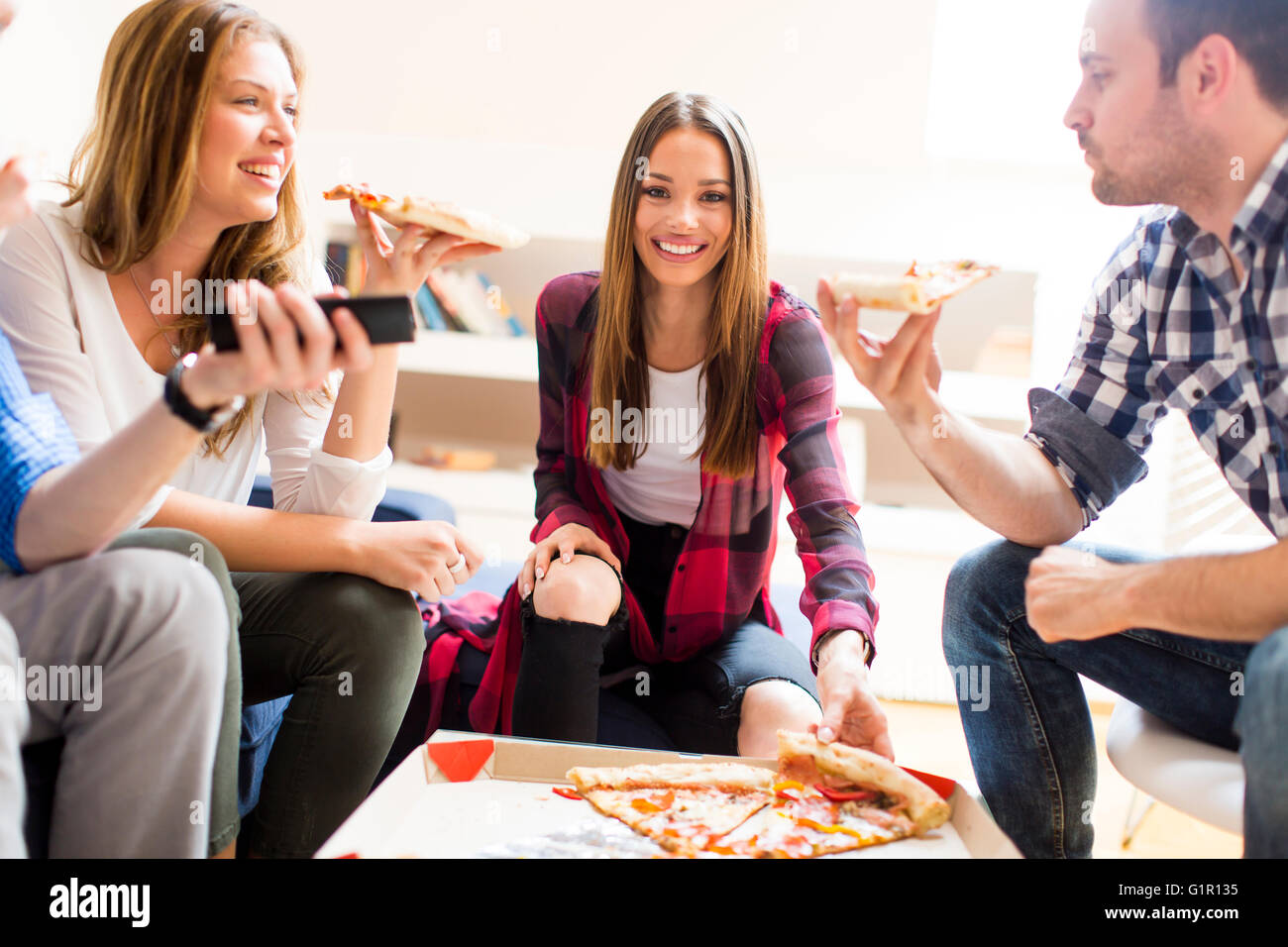 Group of friends eating pizza together at home Stock Photo - Alamy